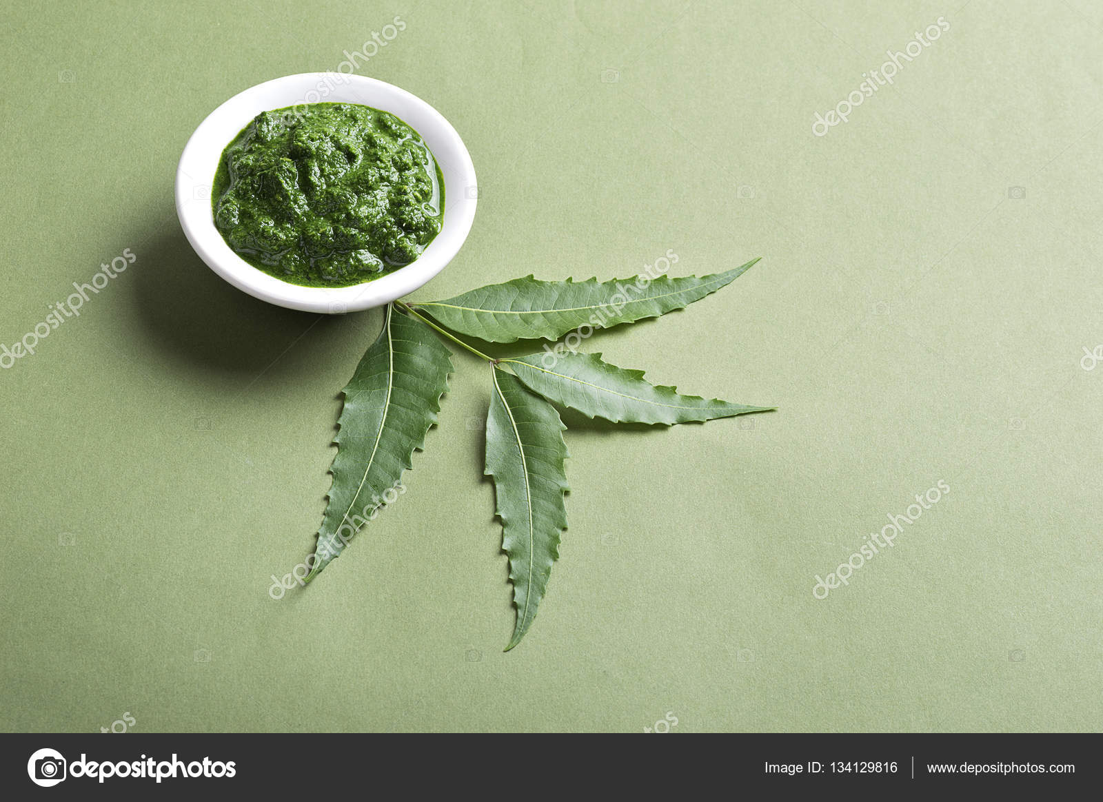 Medicinal Neem leaves with paste in bowl on green background Stock ...