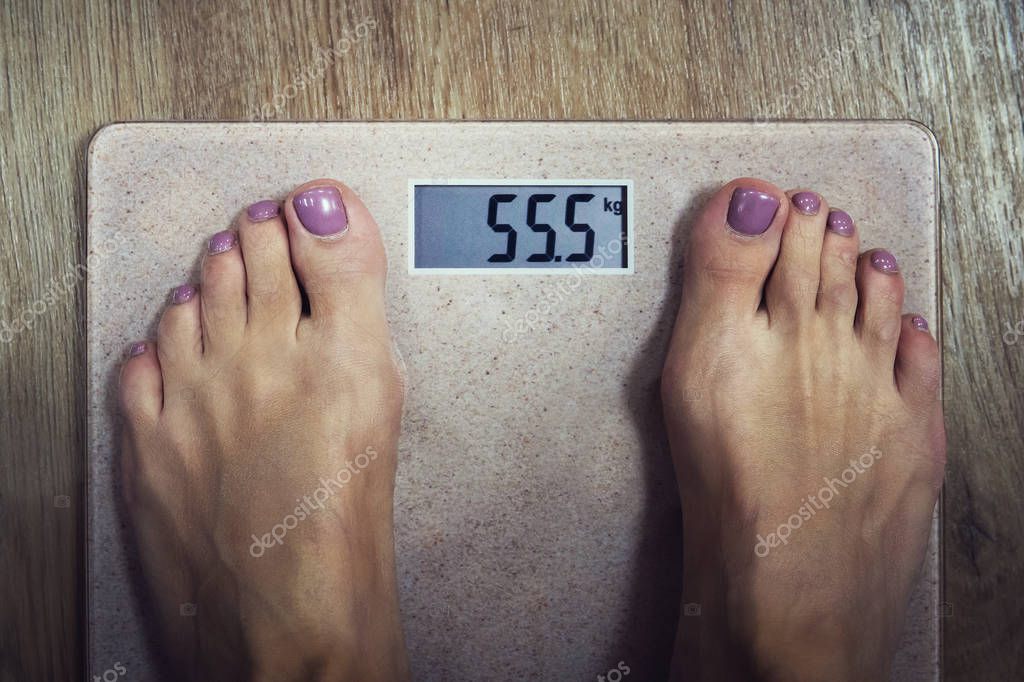 Primer plano de la báscula de baño digital con pies desnudos femeninos ...