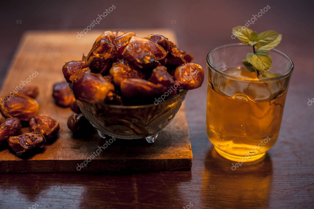 Primer plano de dátiles crudos junto con su jarabe en un vaso con ...