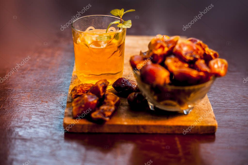 Primer plano de dátiles crudos junto con su jarabe en un vaso con ...