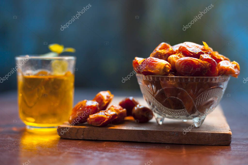 Primer plano de dátiles crudos junto con su jarabe en un vaso con ...