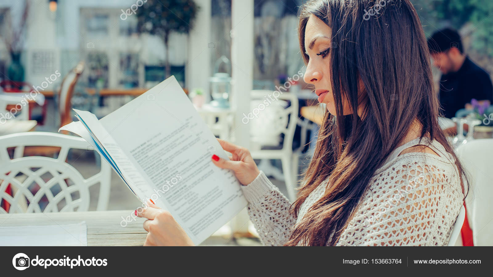 Beautiful woman looking at menu and ordering foods in restaurant ...