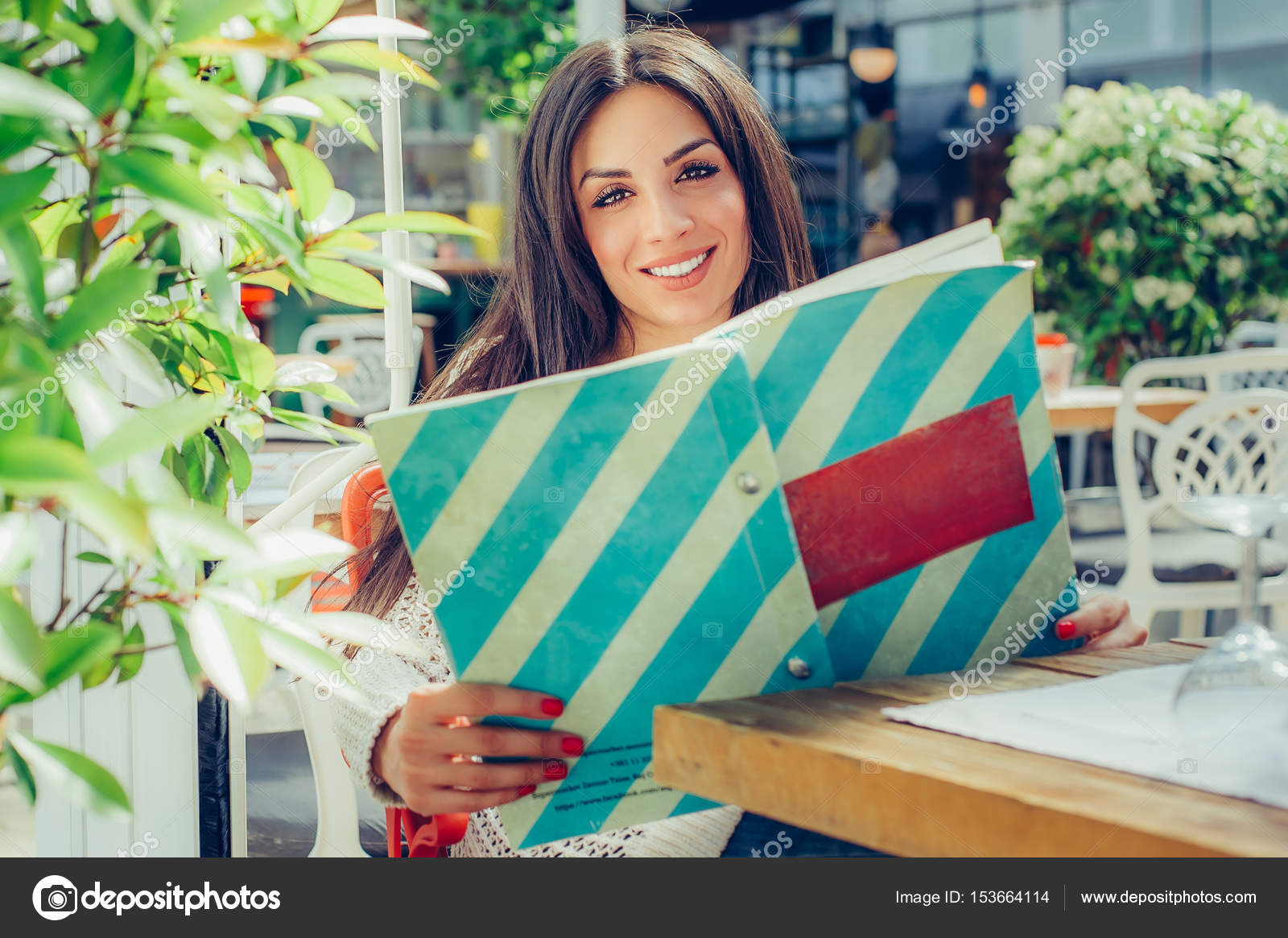 Beautiful woman looking at menu and ordering foods in restaurant ...