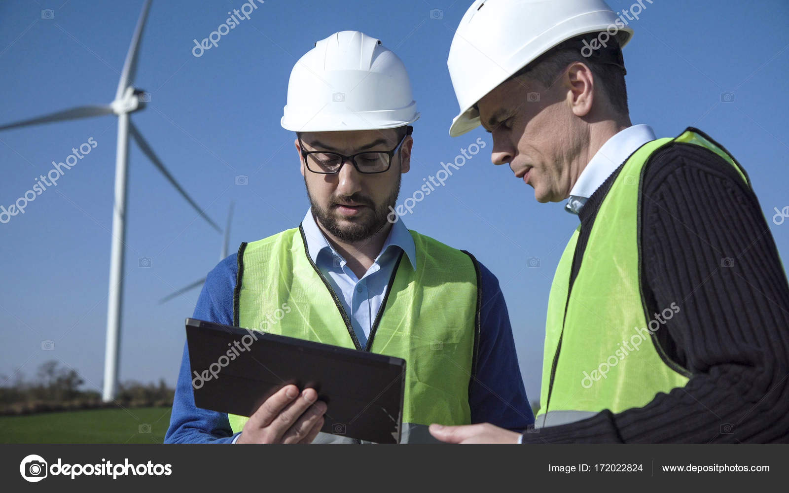 Two engineers discussing against wind turbines — Stock Photo ...