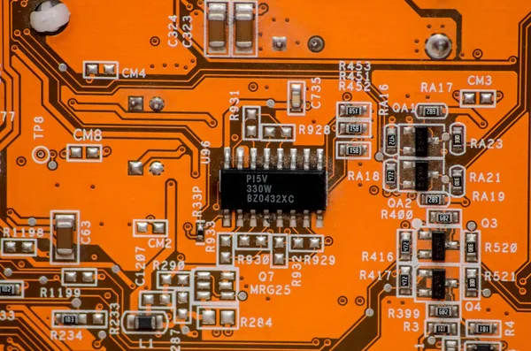 orange electronics computer part chip with many electrical components ...