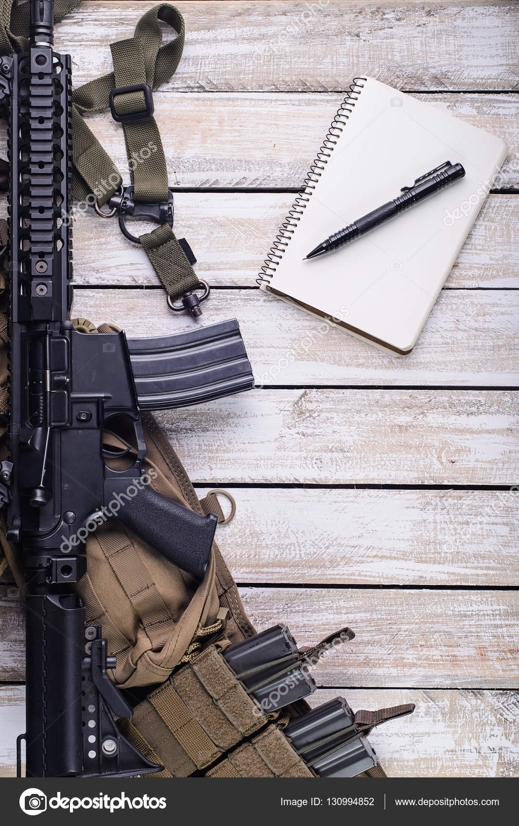 Notebook with pen and rifle Stock Photo by ©Nesterenko_Max 130994852