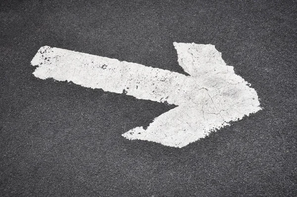 An image of a white arrow painted on the road to indicate to drivers ...