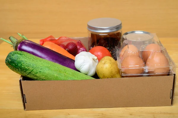 Close-up set of fresh packed food products in cardboard box on wooden ...