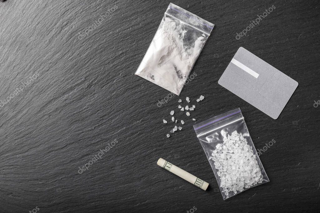 polvo blanco de la droga en una pequeña bolsa de plástico sobre la mesa ...