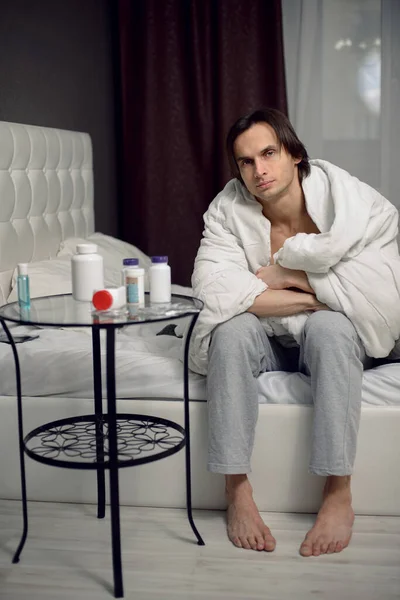 A beautiful young man is ill in quarantine in self-isolation at home ...