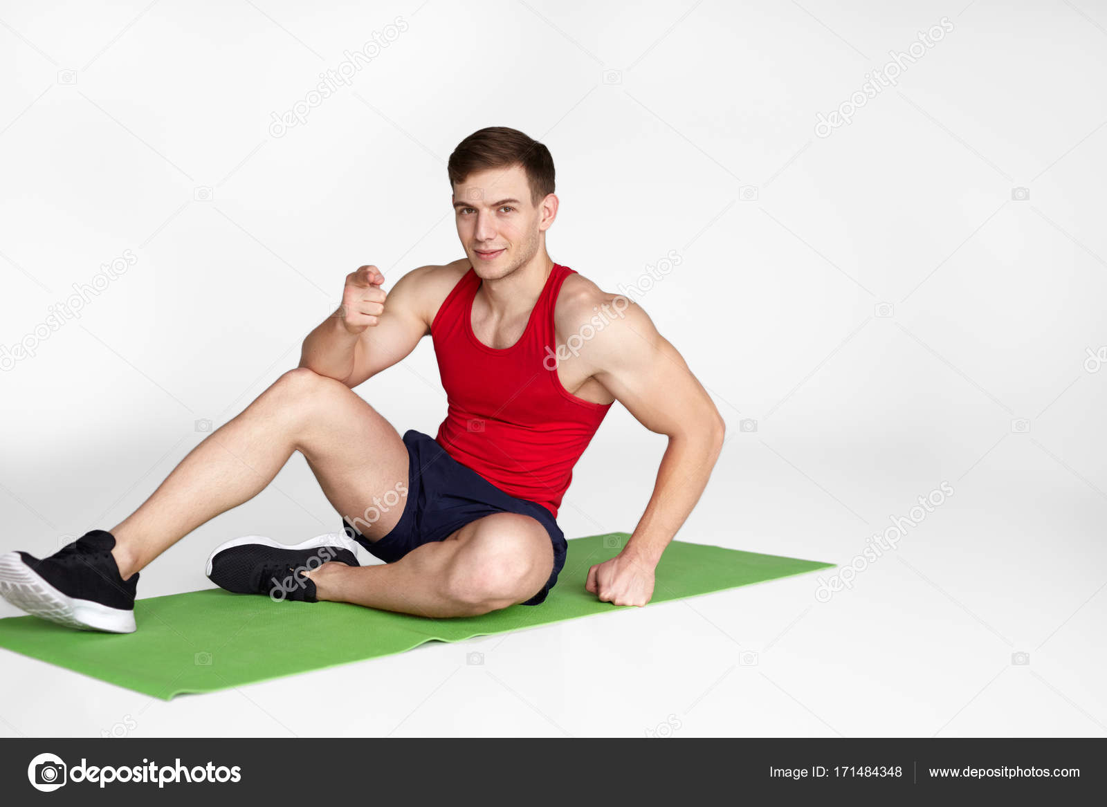 Muscular man sitting on mat Stock Photo by ©kegfire 171484348