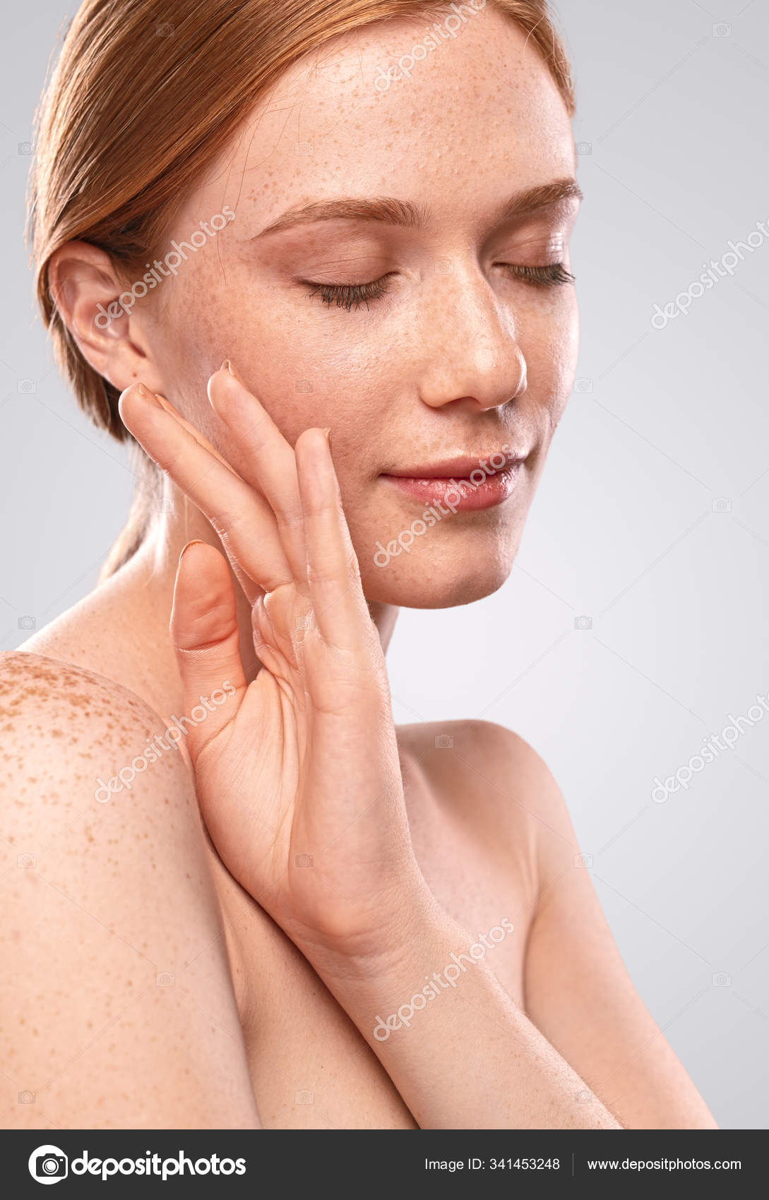 Beautiful ginger female model touching cheek skin Stock Photo by ...