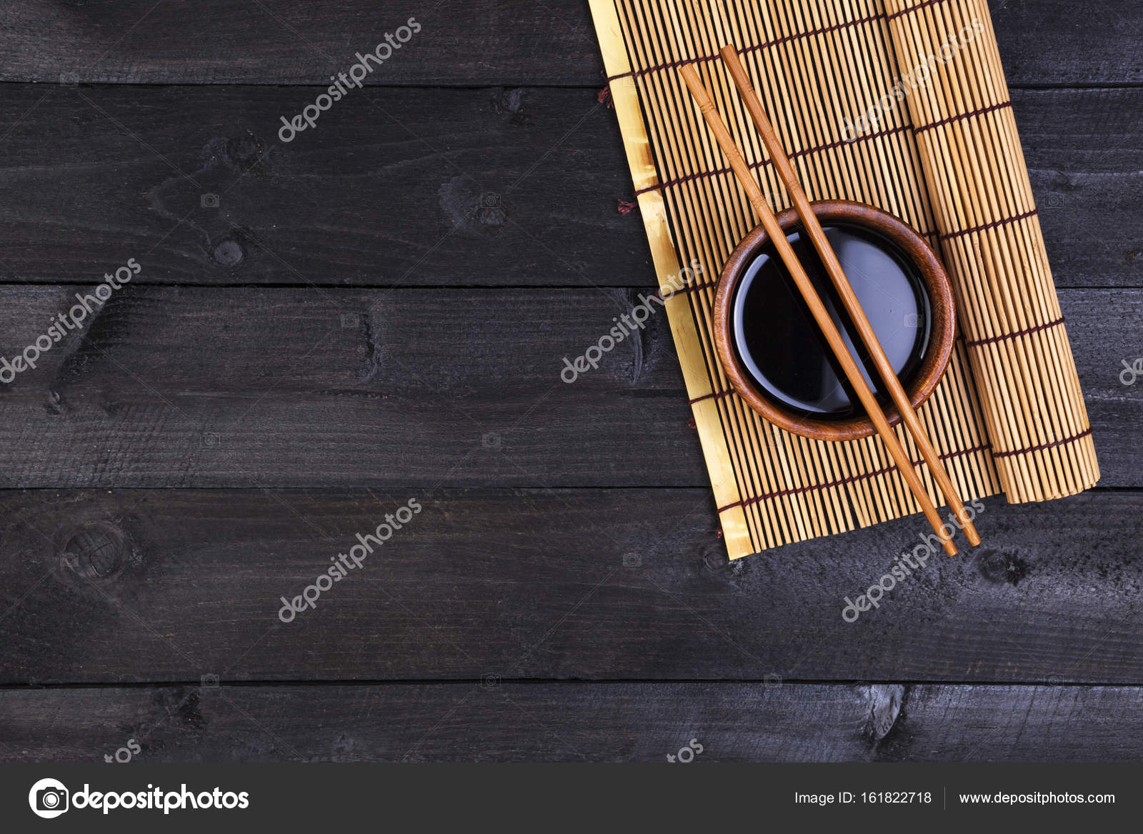 Background for sushi. Bamboo mat and soy sauce on black wooden table ...