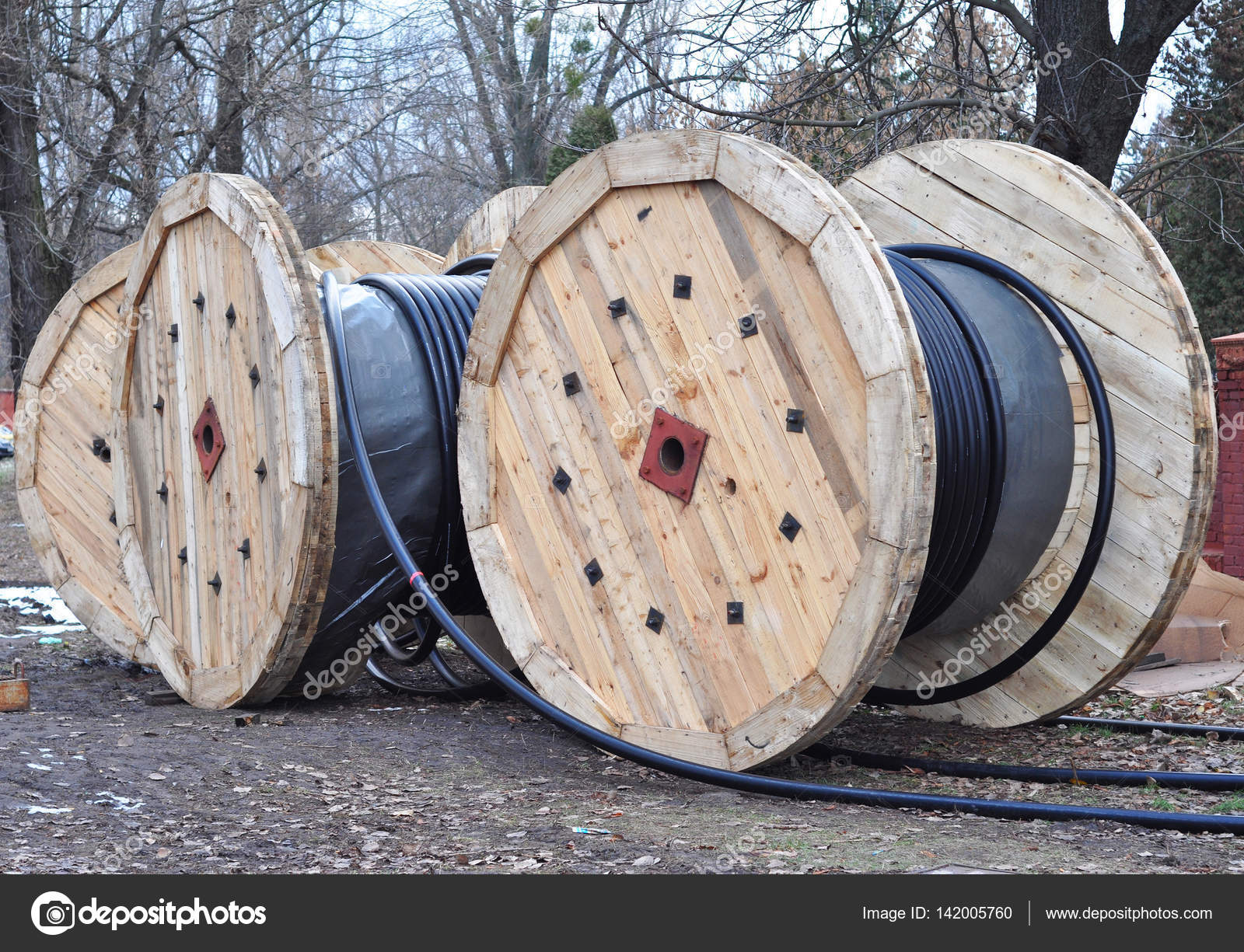 Wooden coil of electric cable and optical fibres on construction site ...