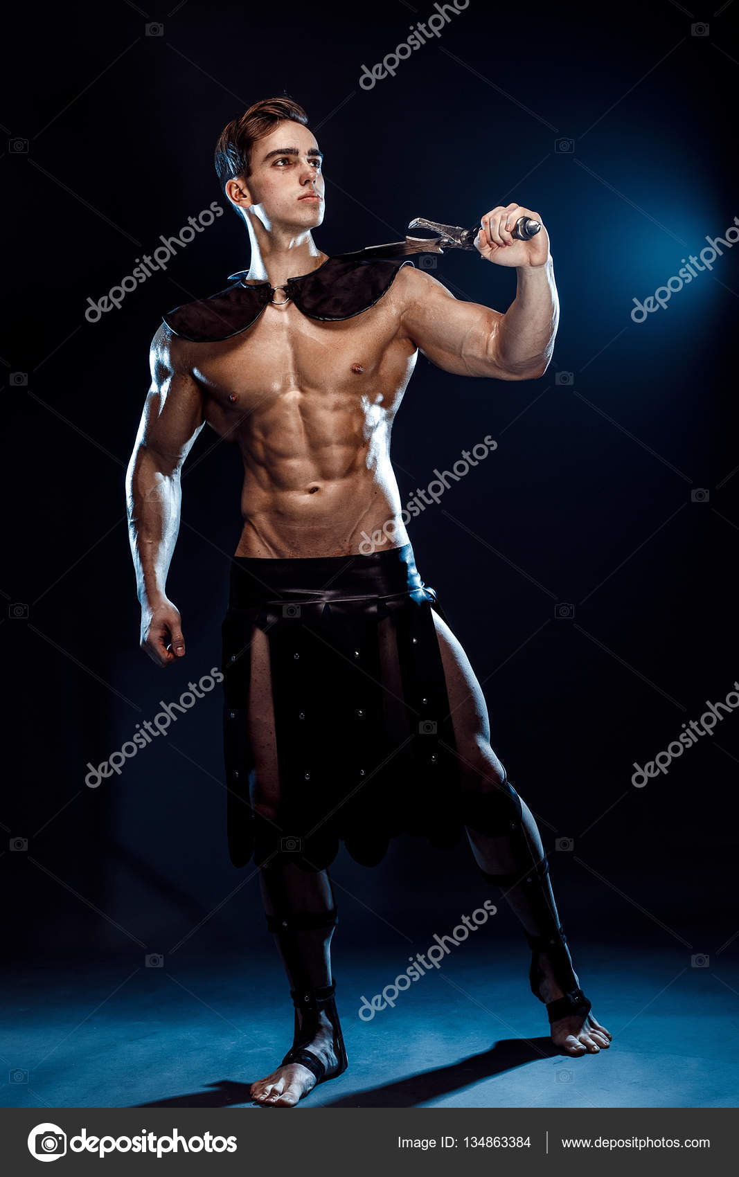 Portrait of handsome muscular gladiator with sword. Isolated. Studio ...