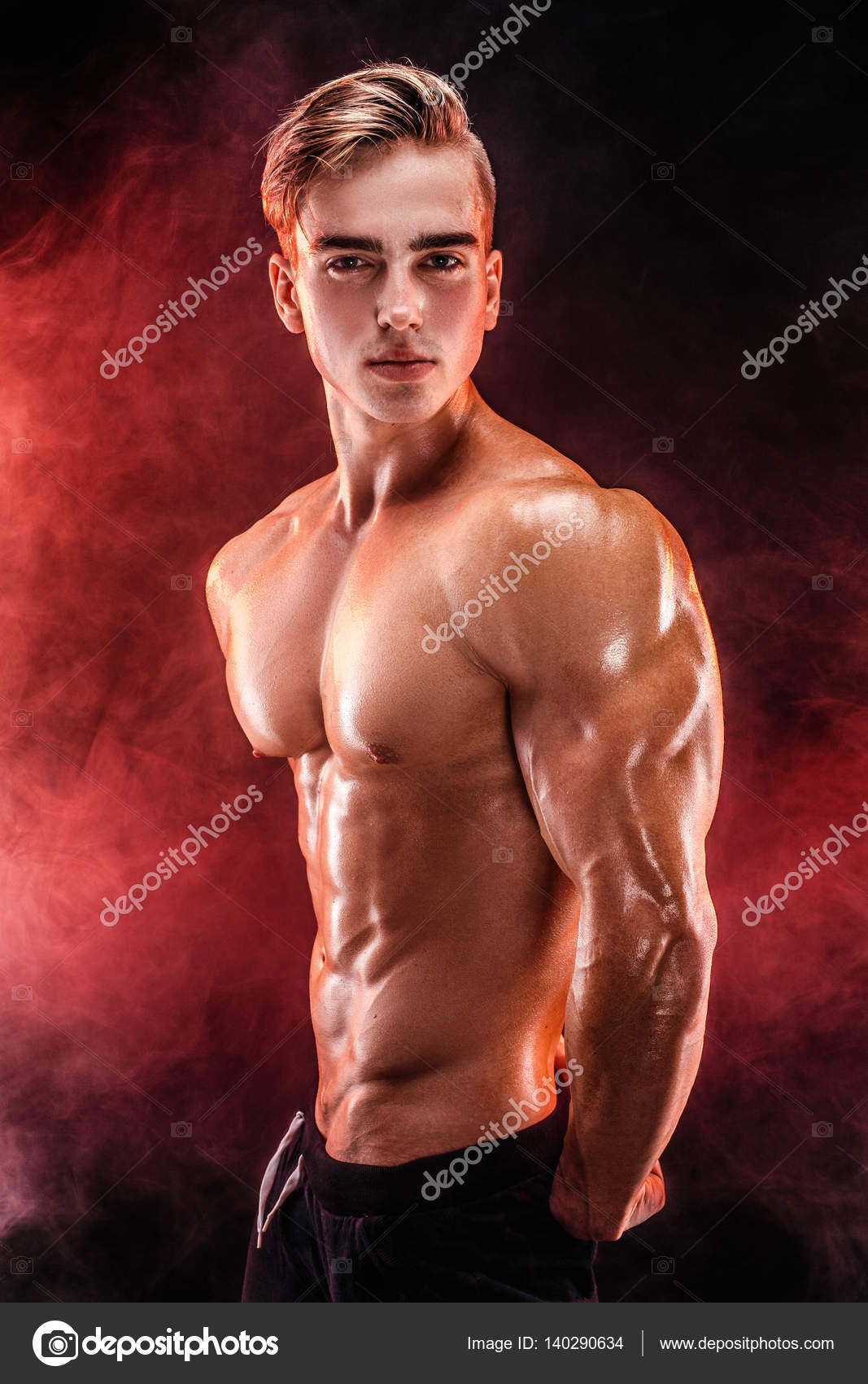 Strong bodybuilder man with perfect abs, shoulders, biceps, triceps ...