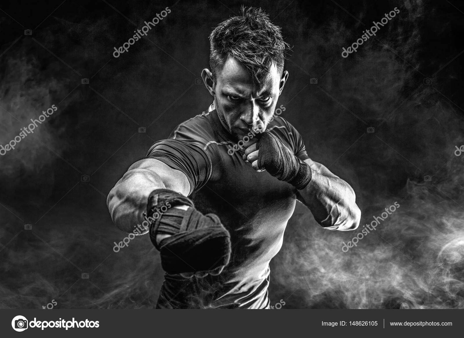 Muscular man punching in smoke. Studio — Stock Photo © zamuruev #148626105
