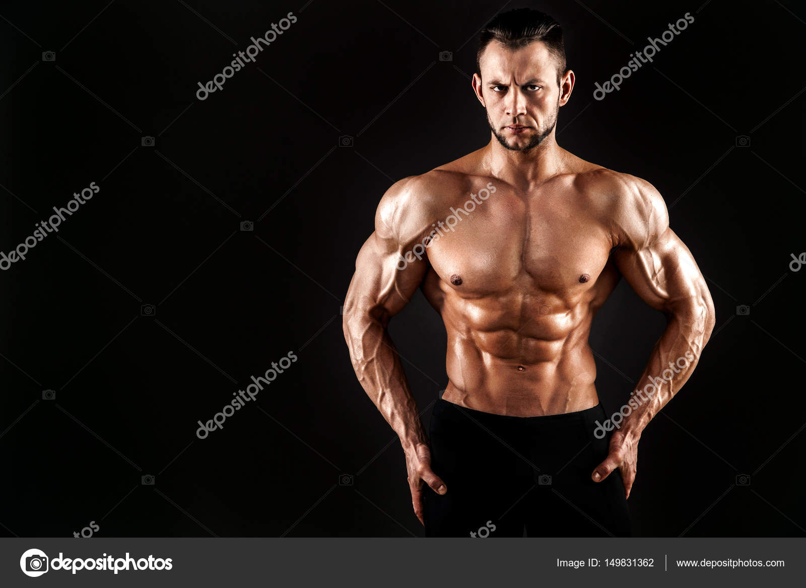 Handsome male model posing at studio in front of a black background ...