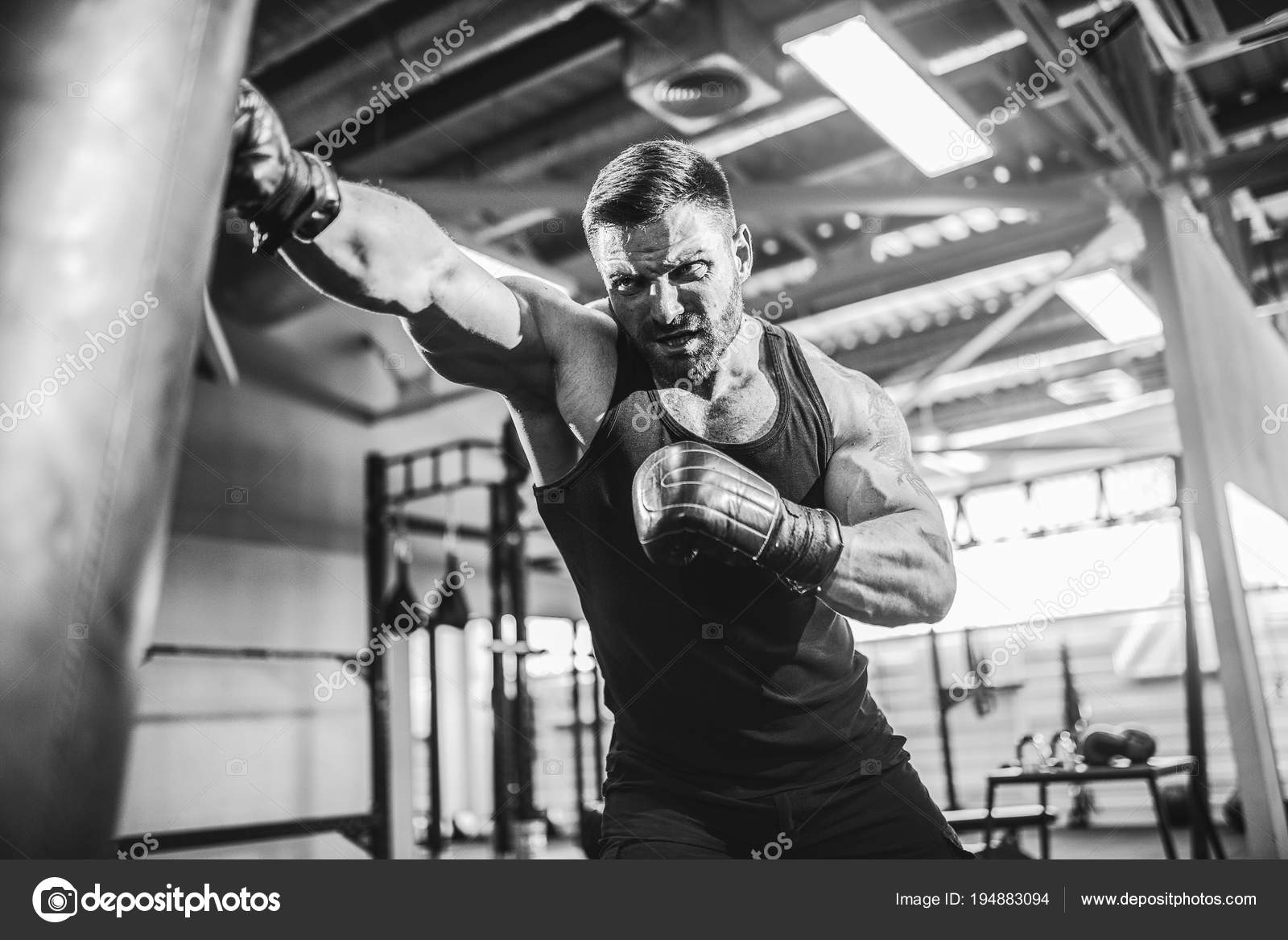 Entrenamiento de boxeador masculino con saco de boxeo en pabellón ...