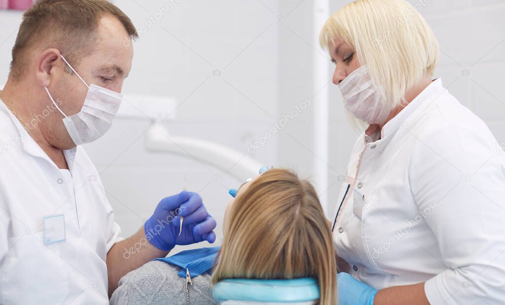 Doctor dentista trata los dientes de una hermosa joven paciente. La ...