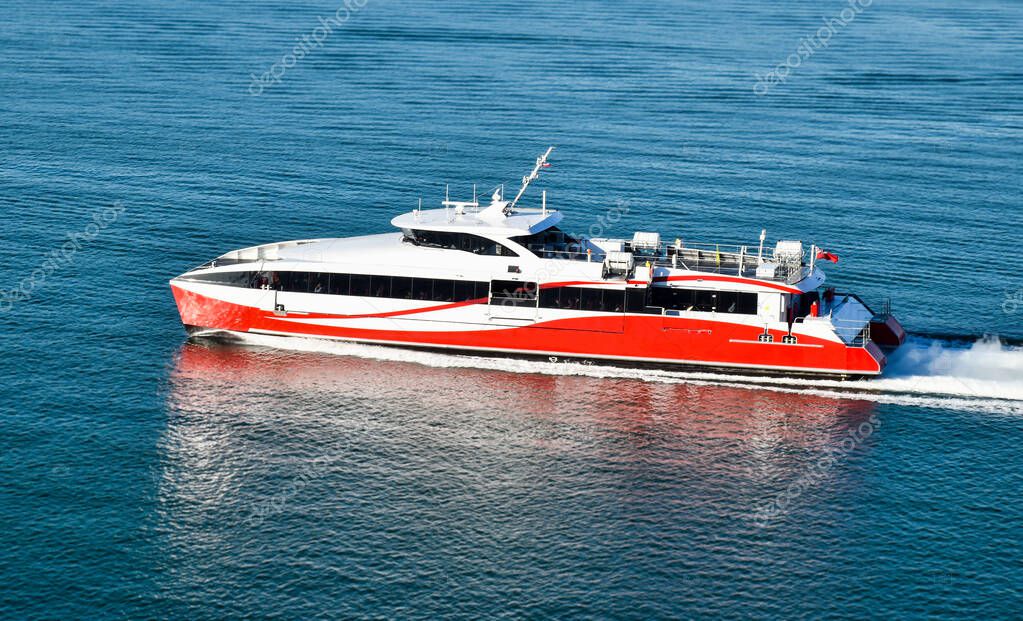 Un moderno ferry en catamarán de alta velocidad viaja rápido a través ...