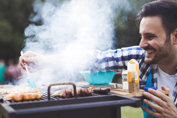 Handsome man grilling meat - Stock Image - Everypixel