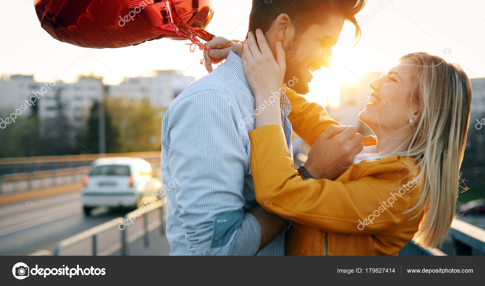 Couple in love cuddling while enjoying beautiful urban sunset together ...