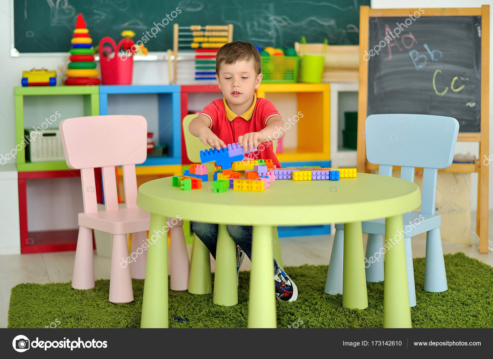 A boy in the children's room playing at the table Stock Photo by ...