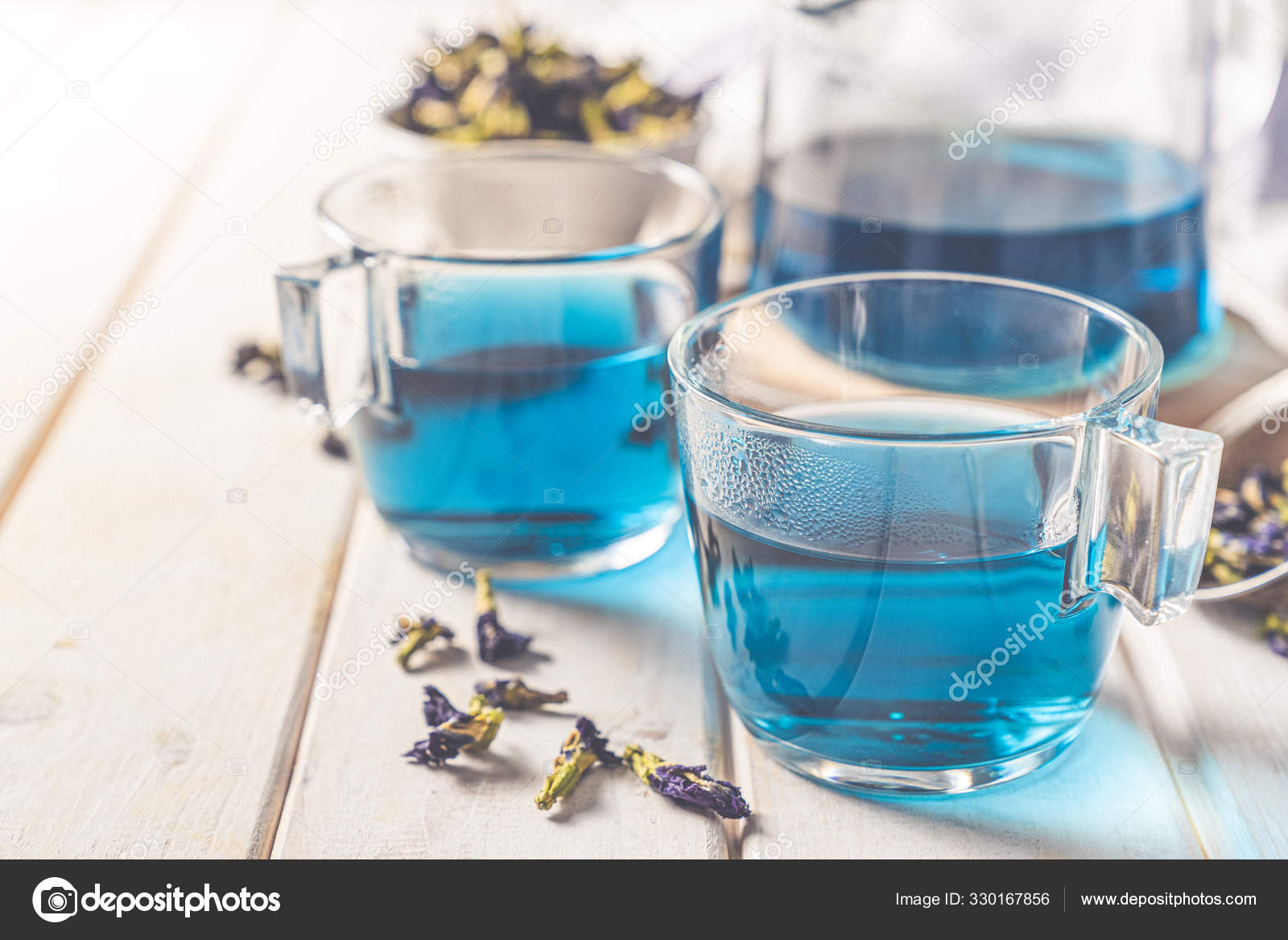 Blue tea in glass cups and glass teapod, white wood background Stock ...