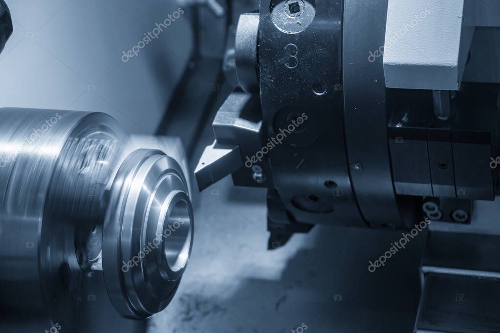 La máquina de torno CNC en proceso de trabajo de metal que forma el corte de las piezas de forma ...