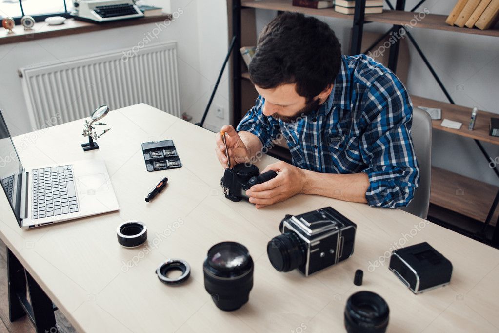 Photographer disassemble photo camera at workplace Stock Photo by ...