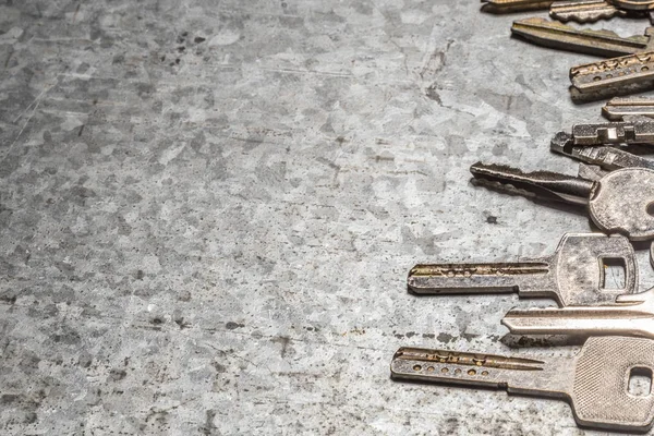 A bunch of old worn keys on the grey concrete wall — Stock Photo ...