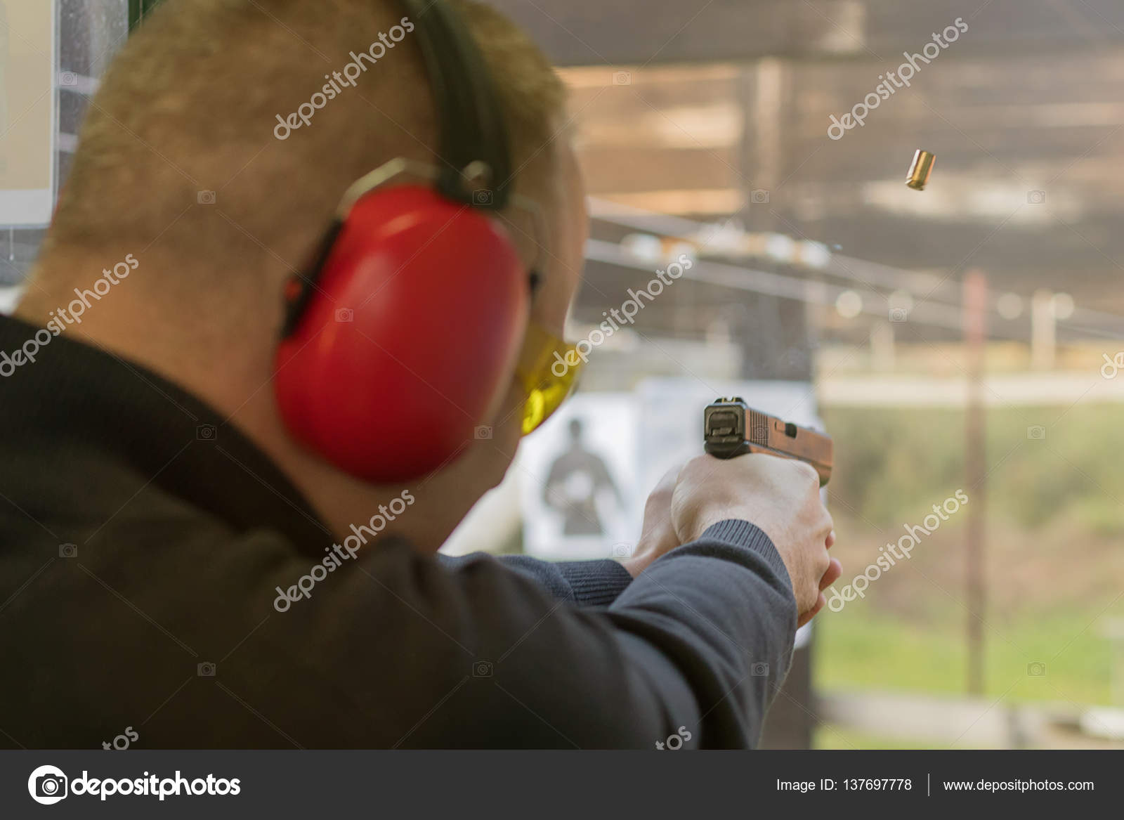 Disparar con una pistola. Hombre disparando pistola en el campo de tiro ...