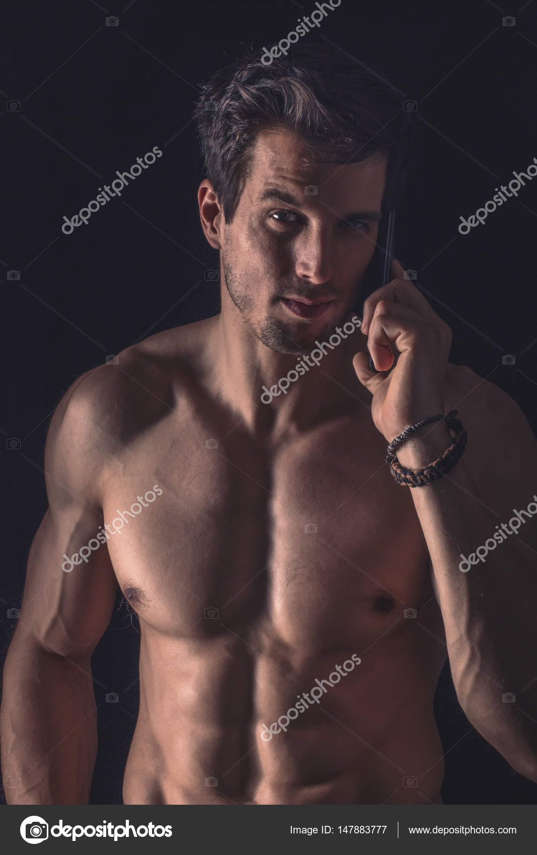 Handsome shirtless muscular young man using cell phone Stock Photo by ©Allexxandar 147883777