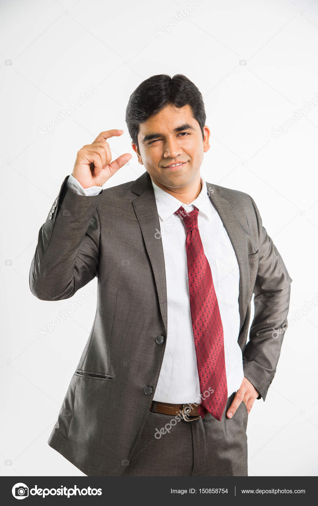 Young indian businessman showing small quantity sign or posing like ...