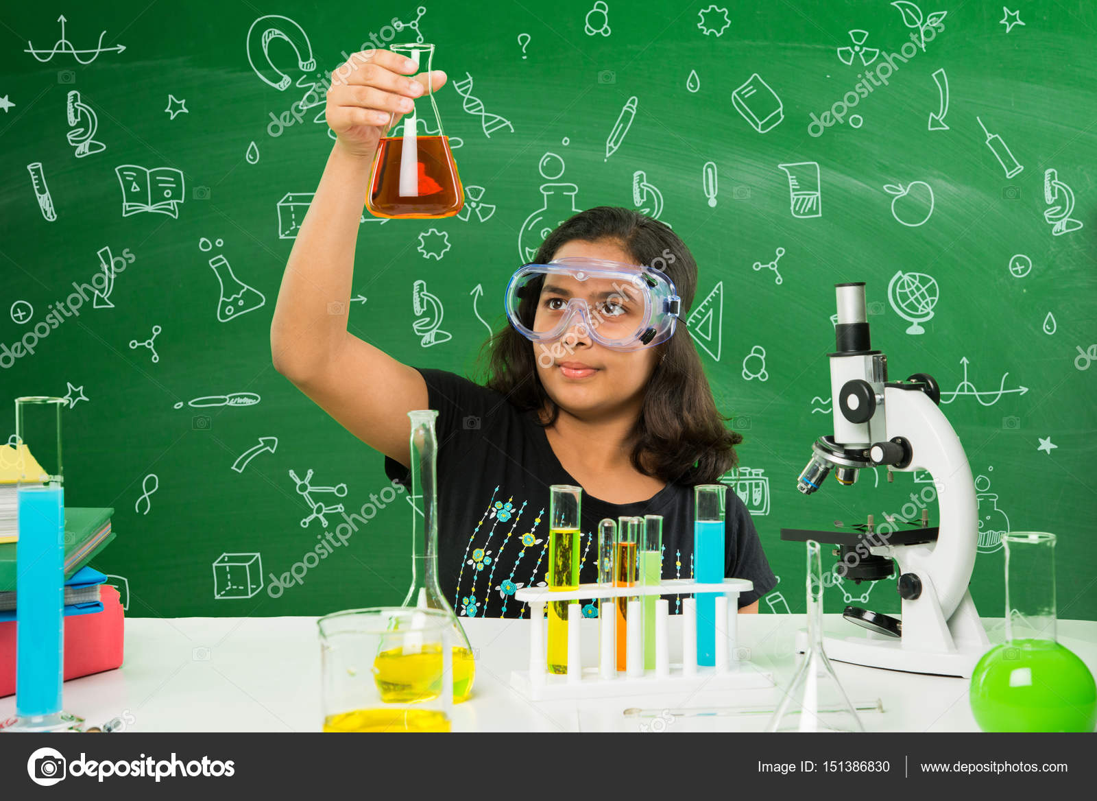 Indian schoolgirl posing with science equipments like test tube, flash ...