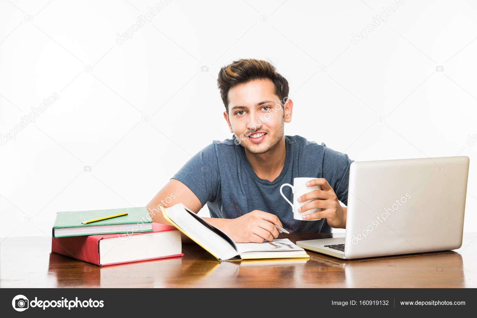 Handsome Indian boy or male college student studying on study table ...