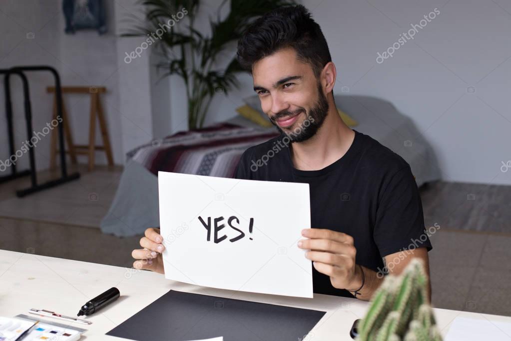 Ilustrador dibuja palabra sí en papel 2024