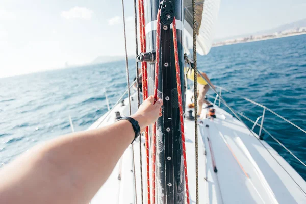 Professional sailor person holding red rope on yacht boat - Stock Image ...