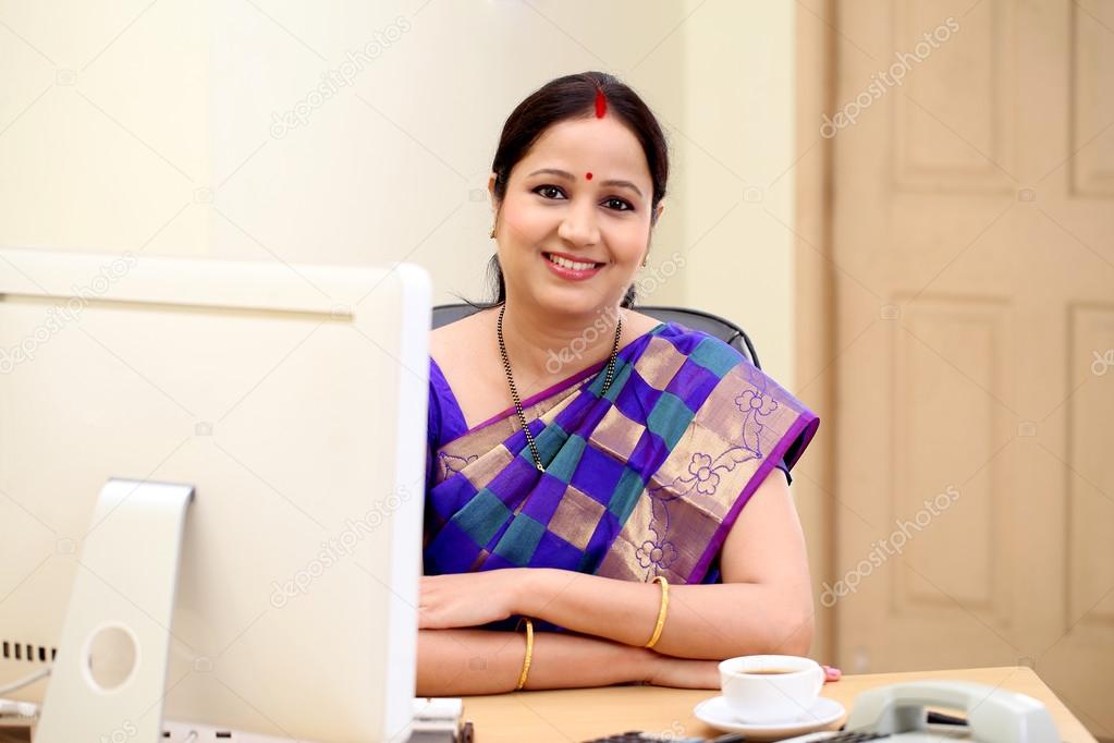Happy traditional Indian business woman at office desk Stock Photo by ... Happy traditional Indian business woman at office desk Stock Photo by ...