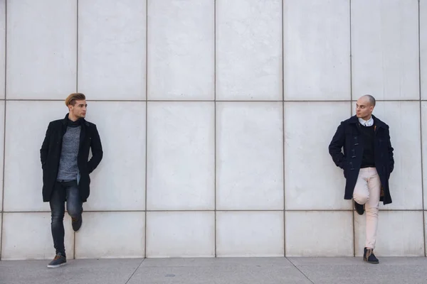 Two young entrepreneurs dressed in modern and elegant clothes leaning ...