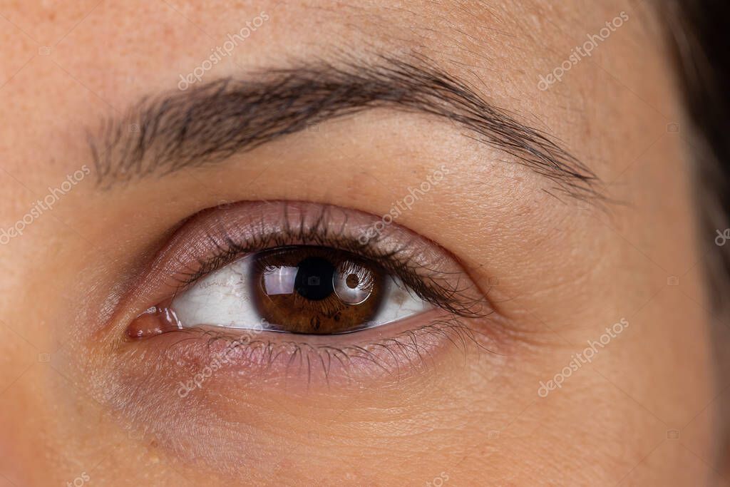 Una vista de cerca del ojo de una mujer joven con un iris marrón ...