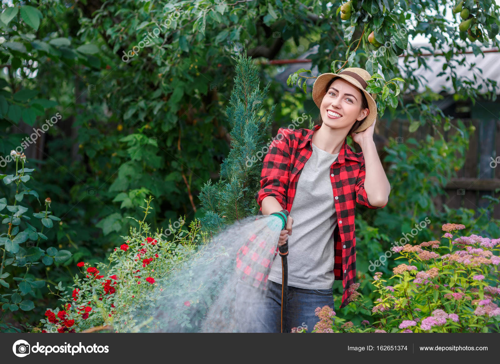Woman gardener watering garden — Stock Photo © AlterPhoto #162651374