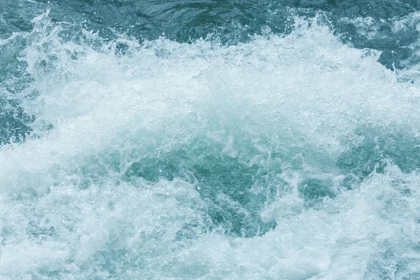 splashes of mountain river waves close up. Churning blue water in the ...