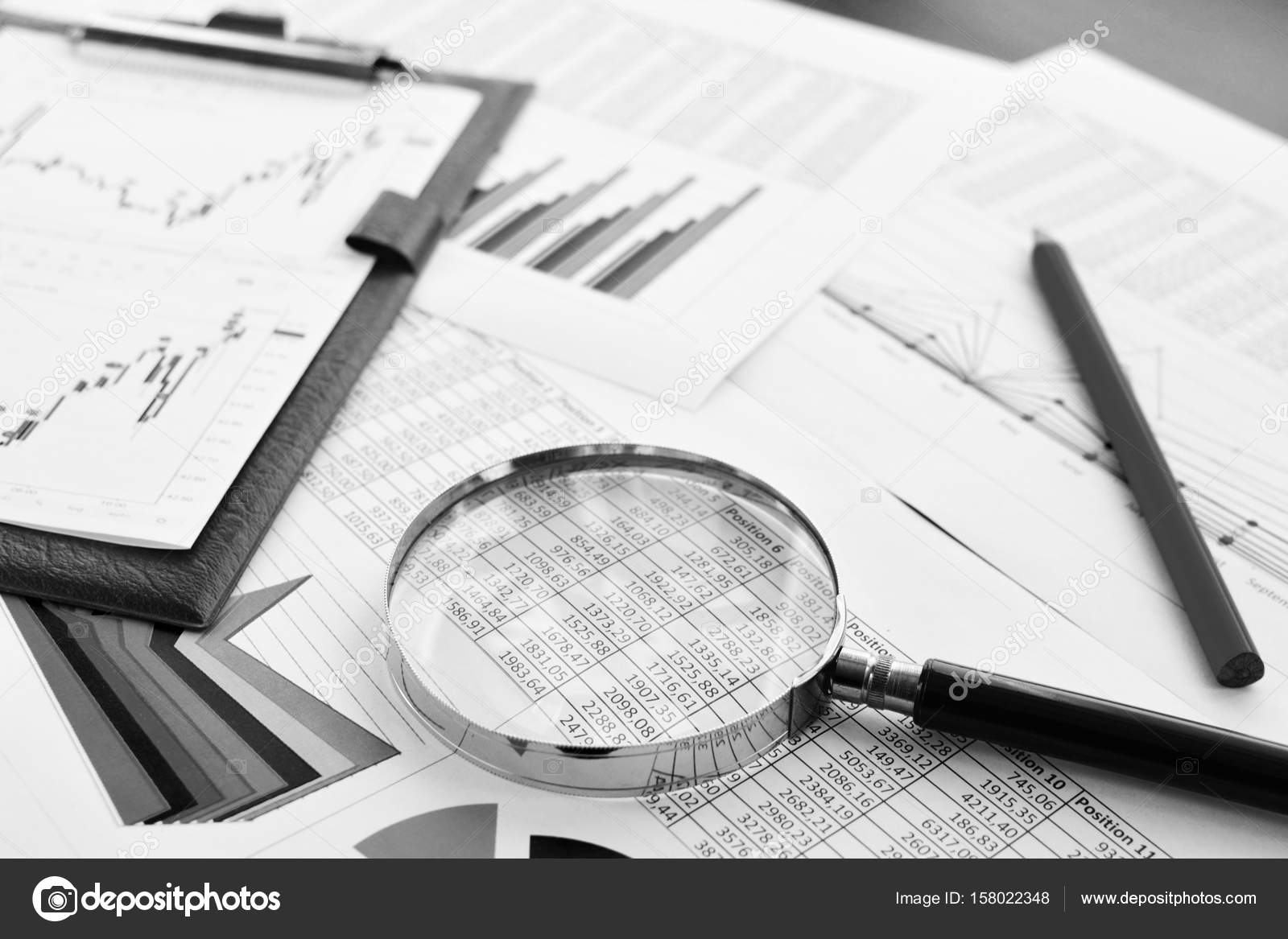 Financial printed paper charts, graphs, diagrams, computer, pen, and ...