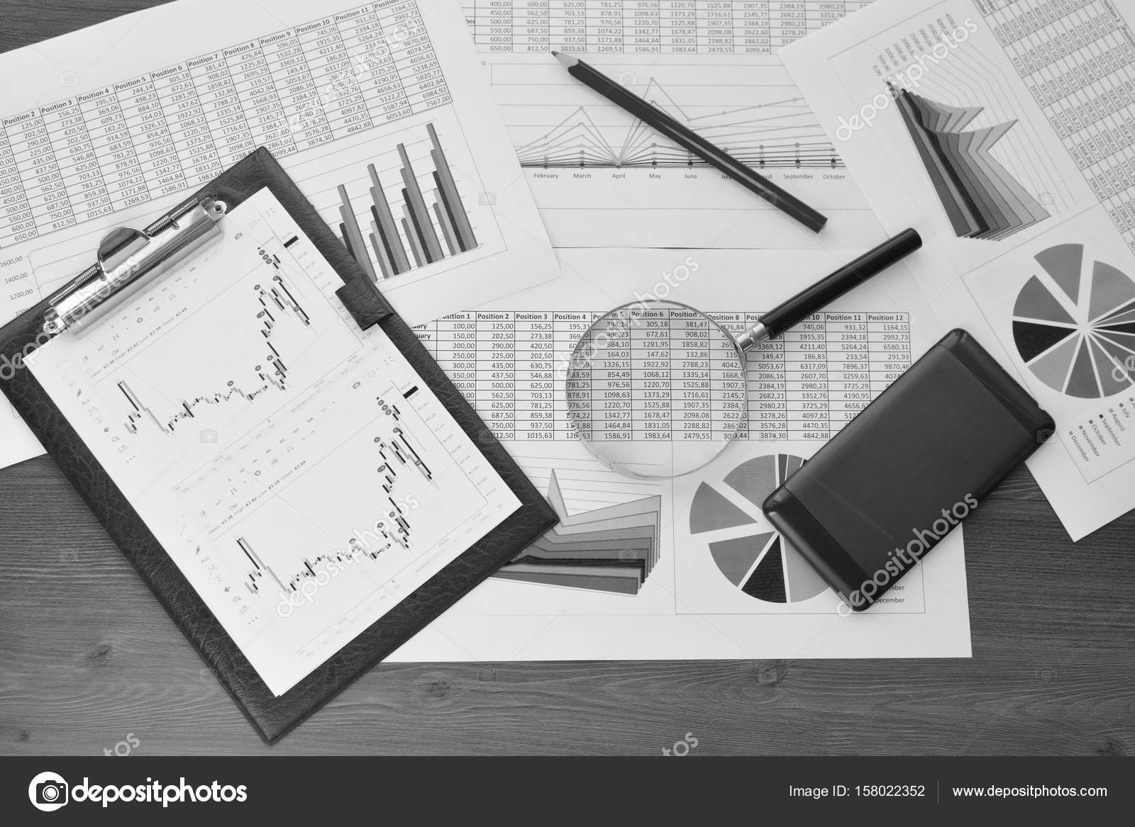 Financial printed paper charts, graphs, diagrams, computer, pen, and ...