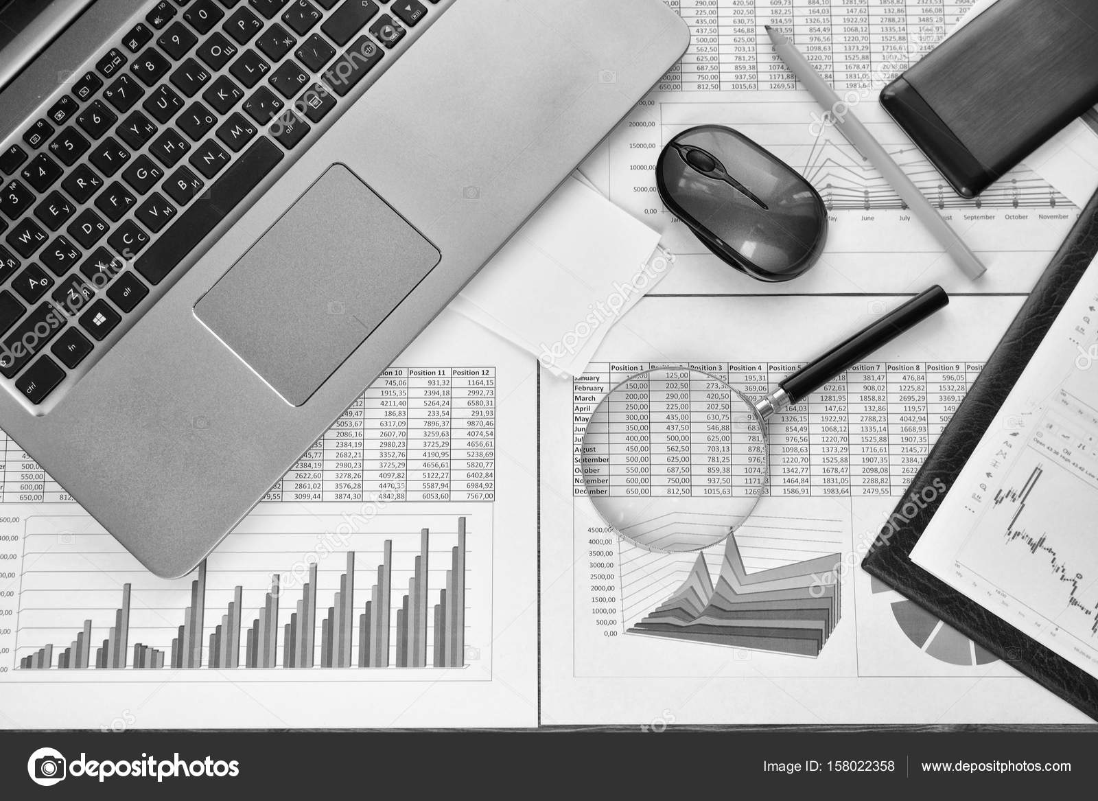 Financial printed paper charts, graphs, diagrams, computer, pen, and ...