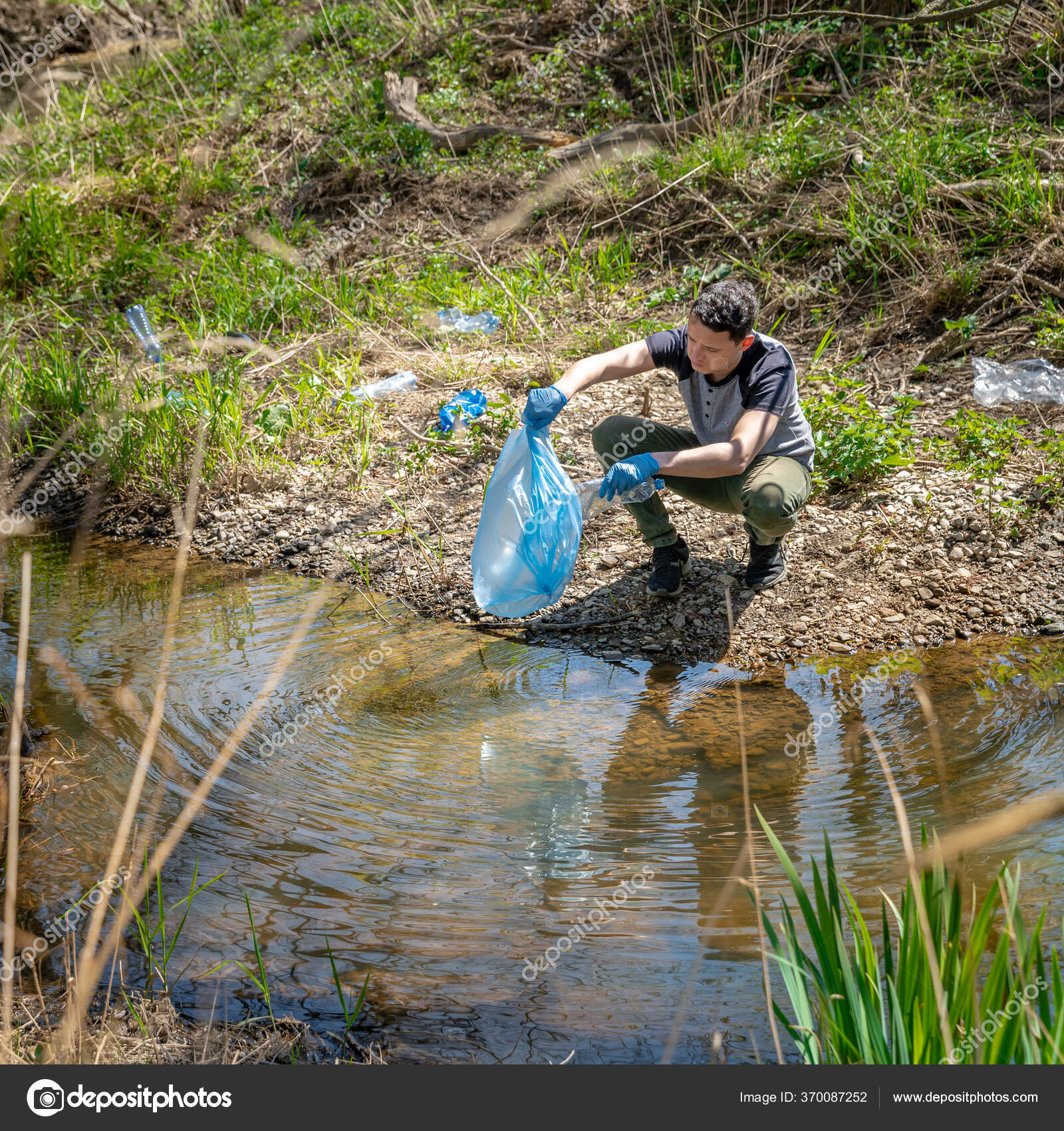 Cleaning of plastic waste on the river bank by a volunteer. Helping ...
