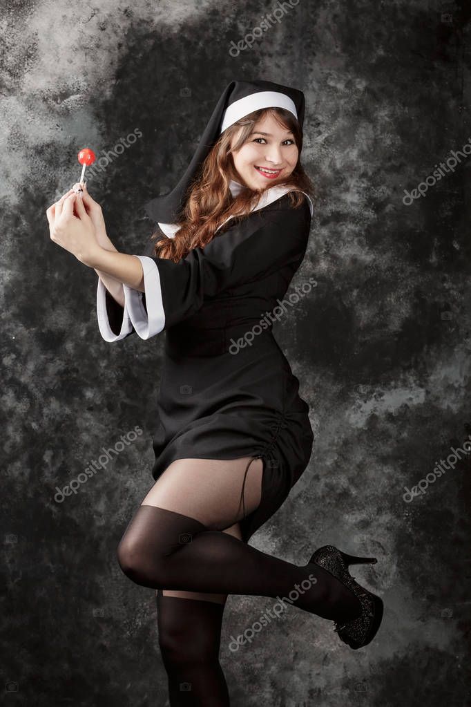 Young Sexy Stockings Nun Holding A Red Candy On A Dark Backgroundattractive Brunette Girl With