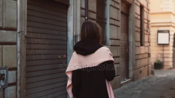Portrait de jeune femme élégante marchant dans l'allée, rue latérale. Happy girl explore la ...